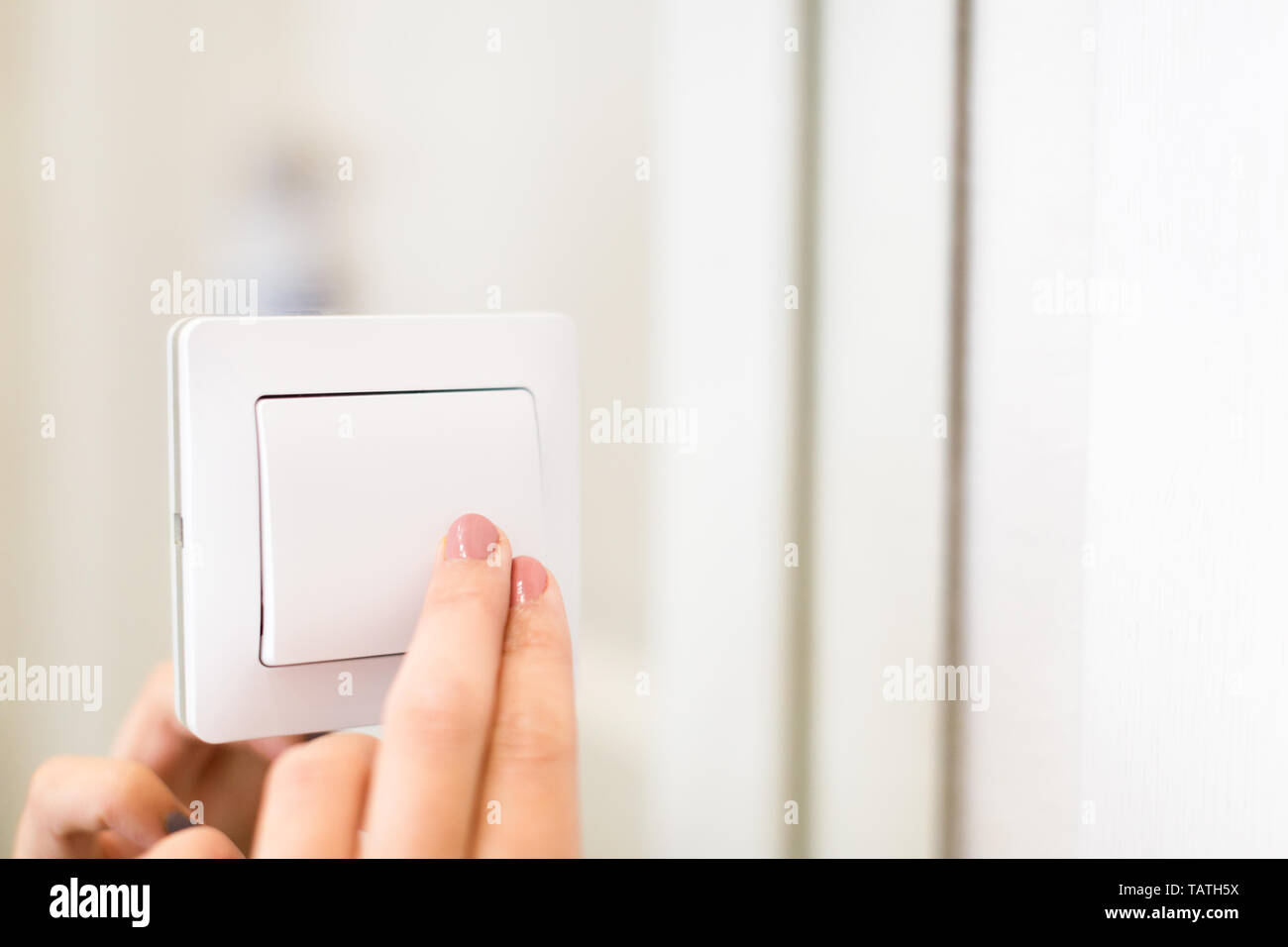Hand turning wall light switch Stock Photo - Alamy