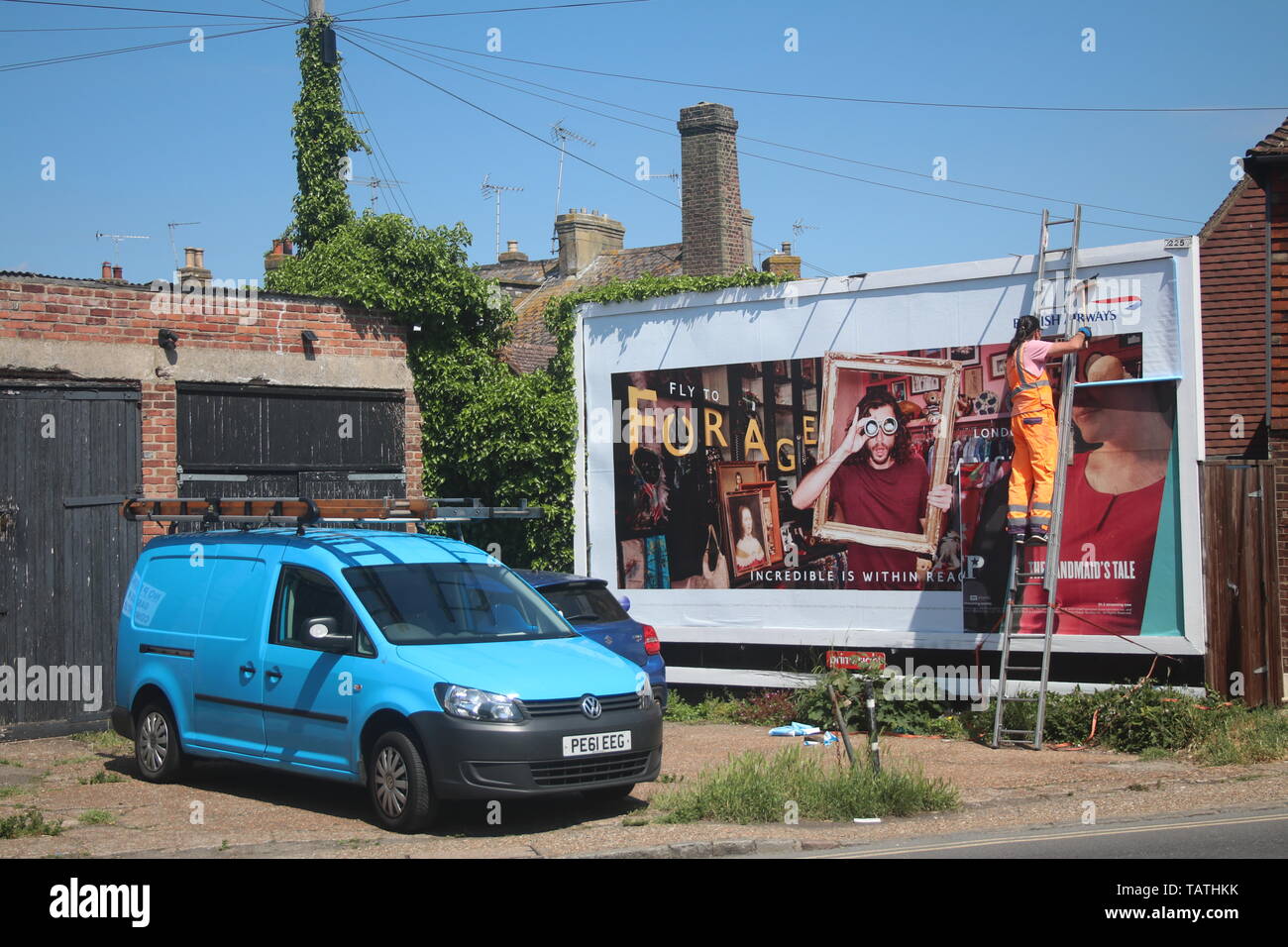A MAN UP A LADDER POSTING AN ADVERTISING BILLBOARD POSTER Stock Photo ...