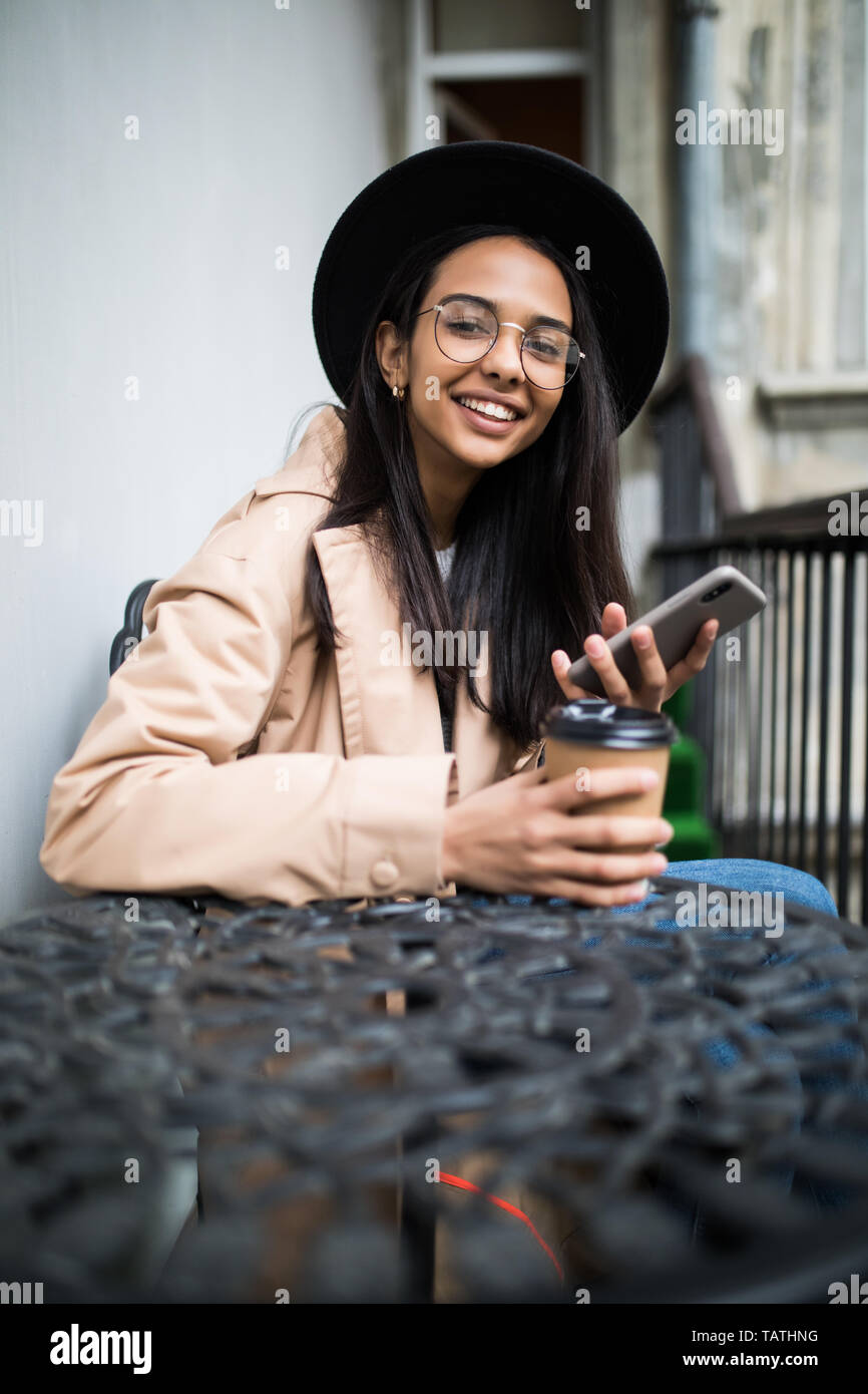 Pretty cheerful young blonde girl in smart casual eclectic outfit sits ...
