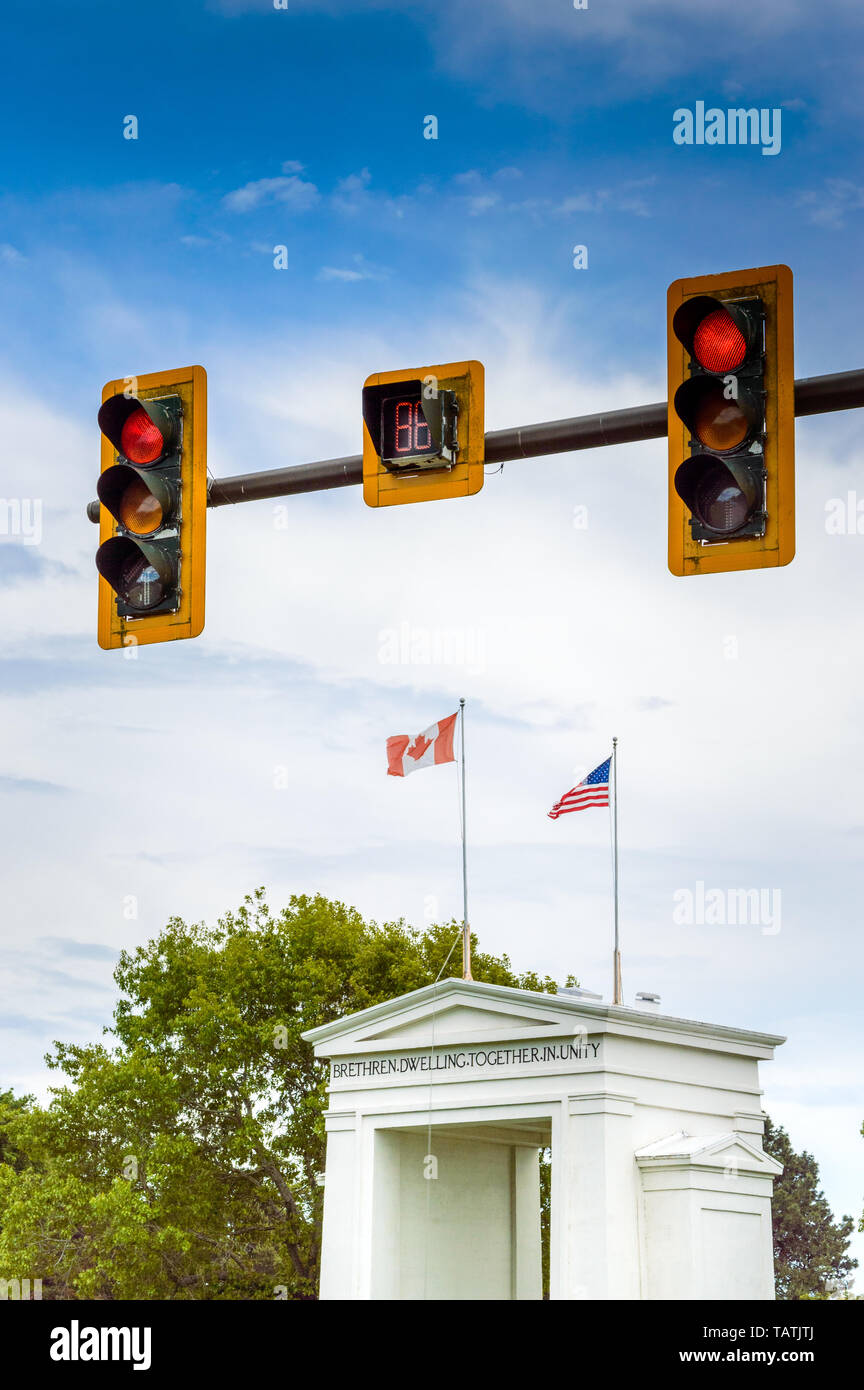 Red traffic light above Canada and USA flags on top of Peace Arch ...