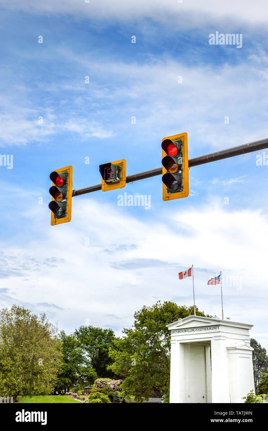 Red traffic light above Canada and USA flags on top of Peace Arch ...