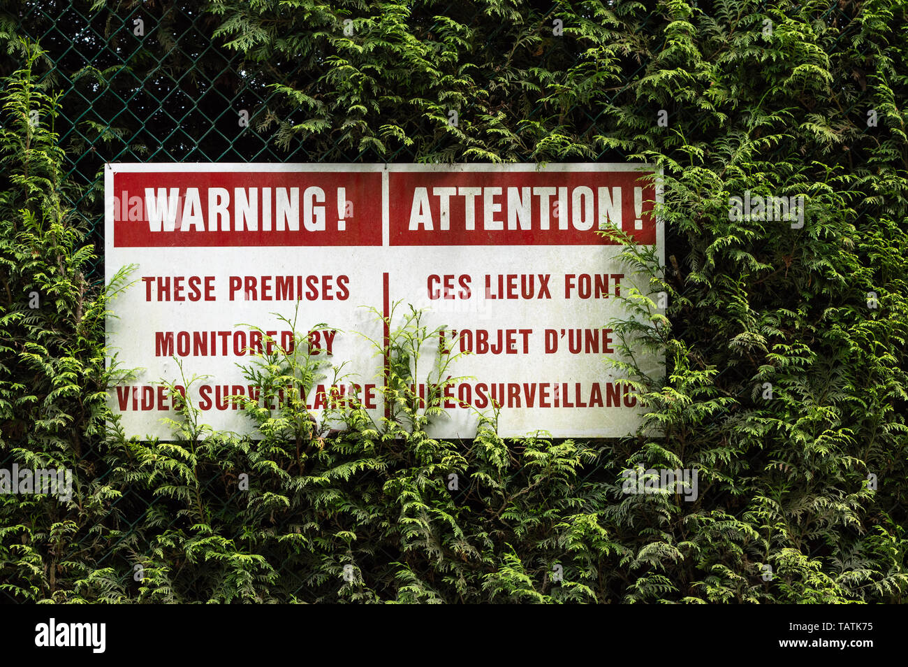 Bi-lingual English and French language surveillance warning sign with ...