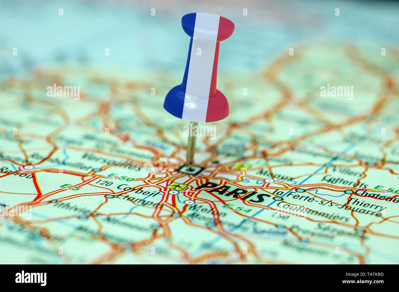 push pin with french flag stuck on a map centred on the city of Paris ...