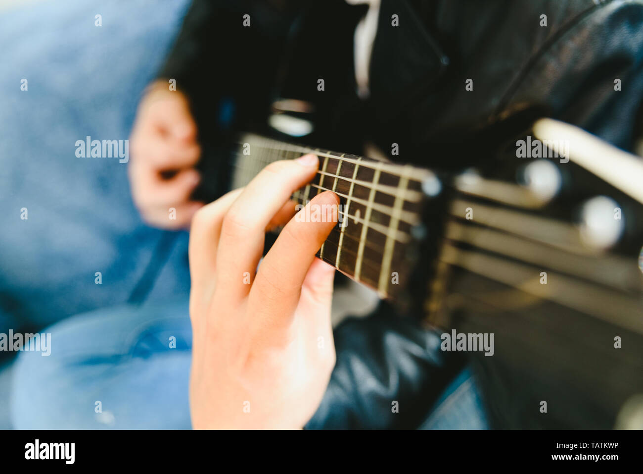 Detail of the fingers of a guitarist placed on the fret of the mast of ...