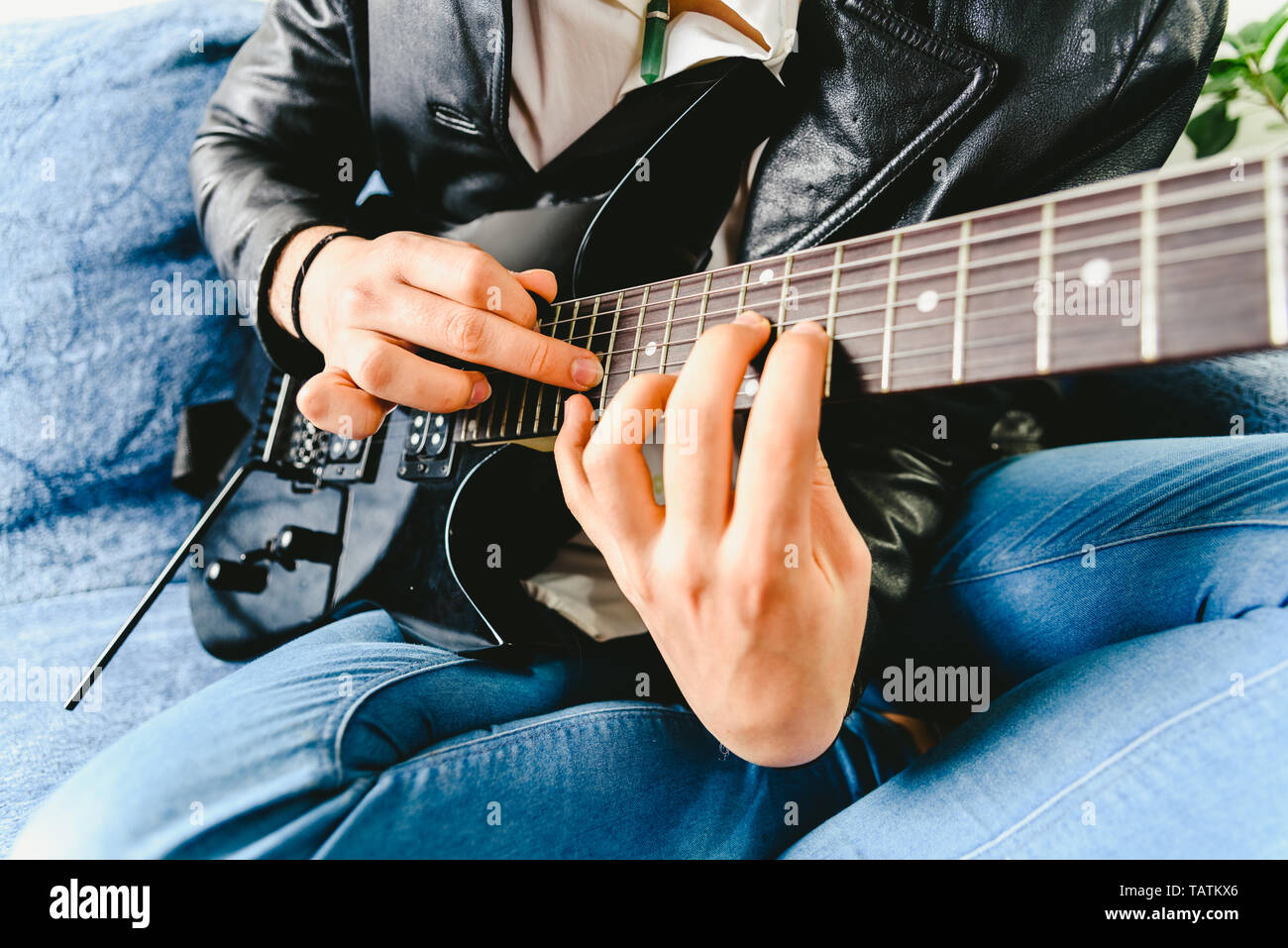 Detail of the fingers of a guitarist placed on the fret of the mast of ...