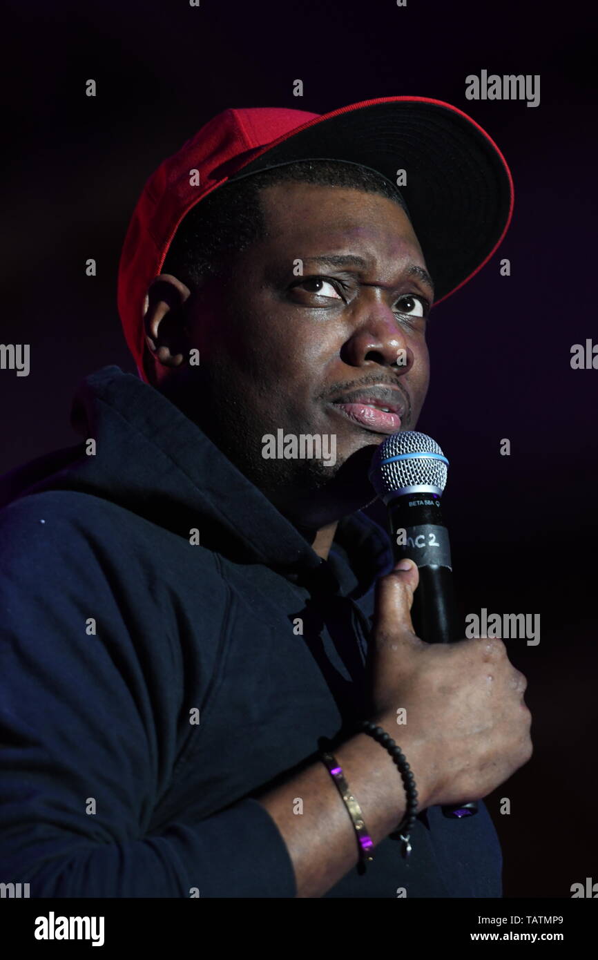 Comedian Michael Che is shown performing on stage during a "live" stand ...
