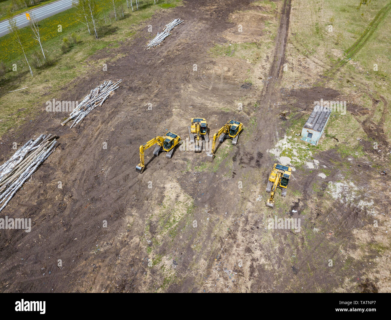 Aerial top view of four yellow crawler excavators standing on ground ...