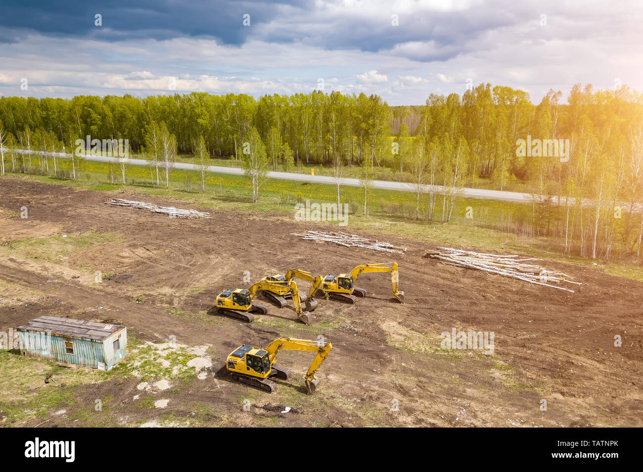 Aerial top view of four yellow crawler excavators standing on ground ...