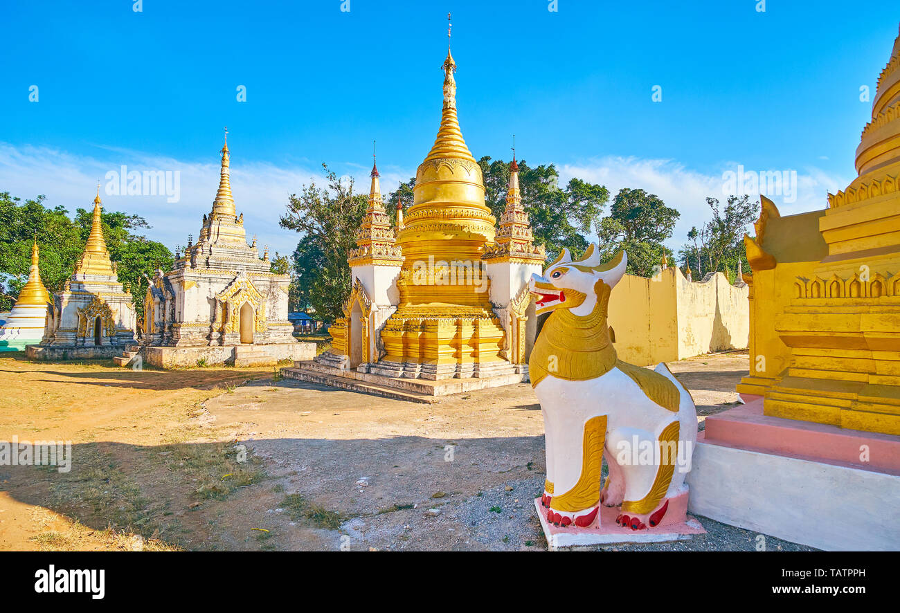 The ornate pagodas of Nget Pyaw Taw burial complex with a sculpture of ...