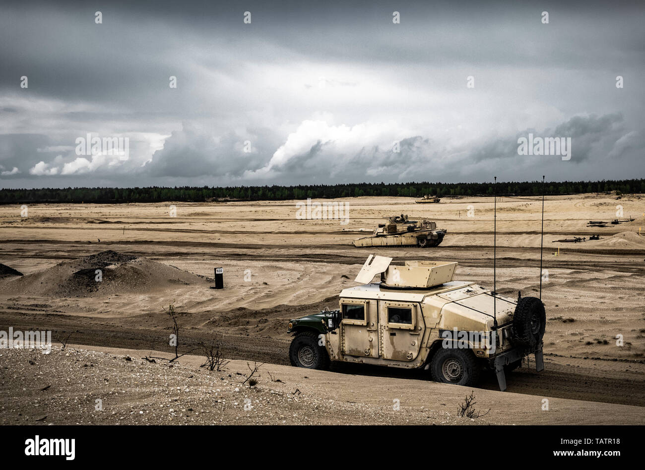An Army Humvee drives alongside M1 Abrams tanks belonging to the 3rd ...