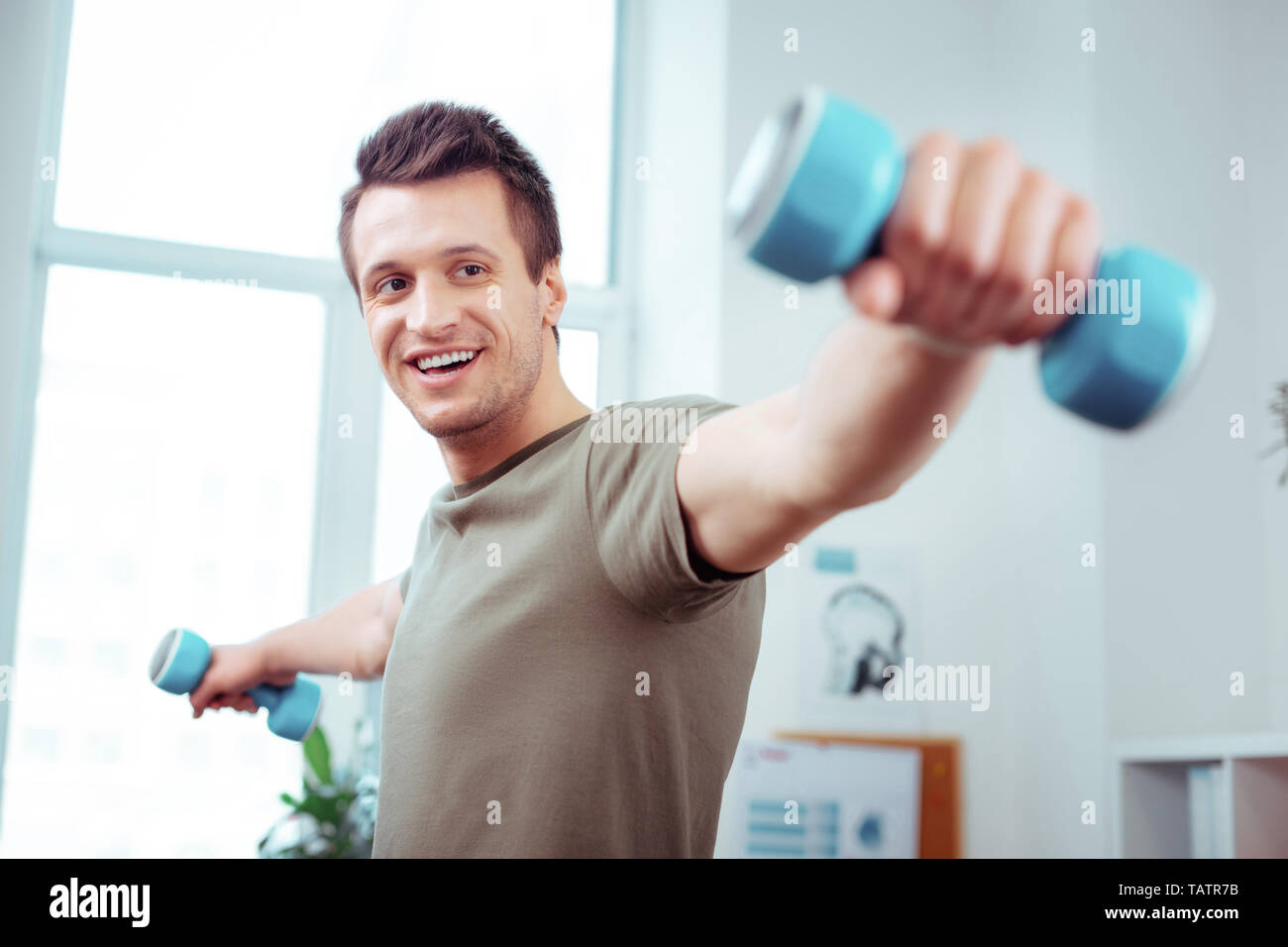 Sport lover. Happy young man smiling while enjoying his sports workout ...