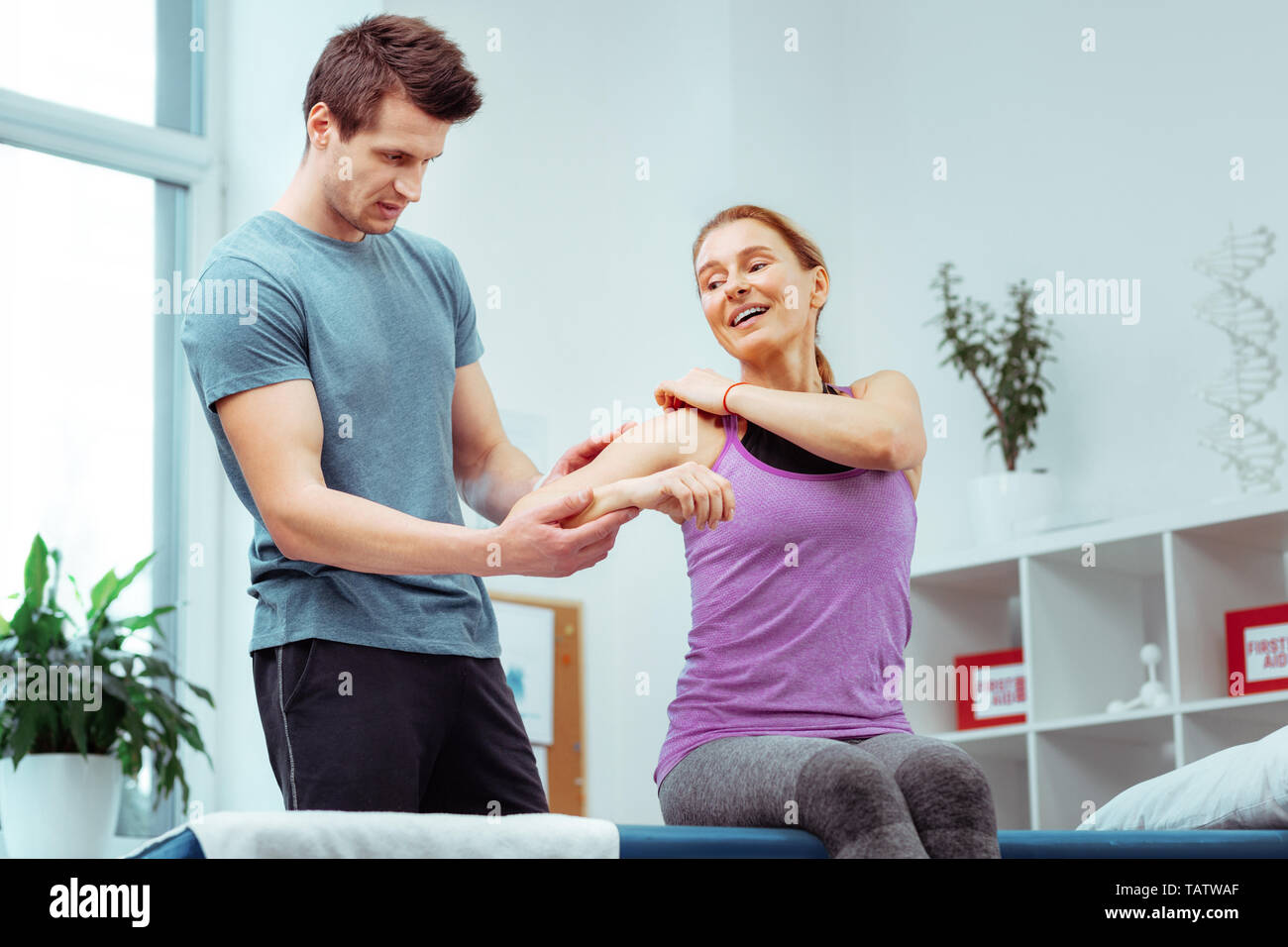 Unpleasant pain. Nice positive woman pointing at her back while feeling ...