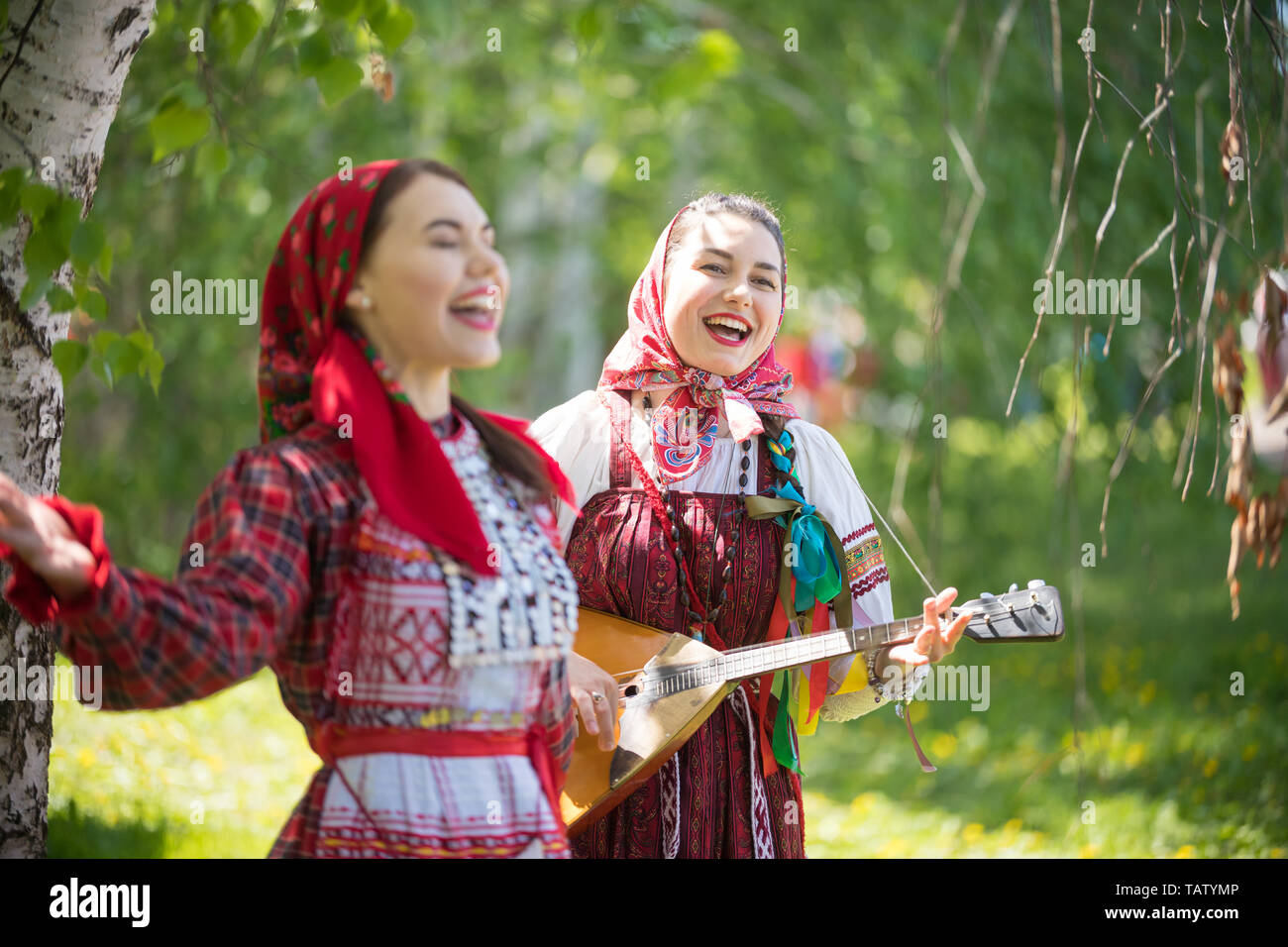 Two young attractive woman in traditional russian clothes singing in ...