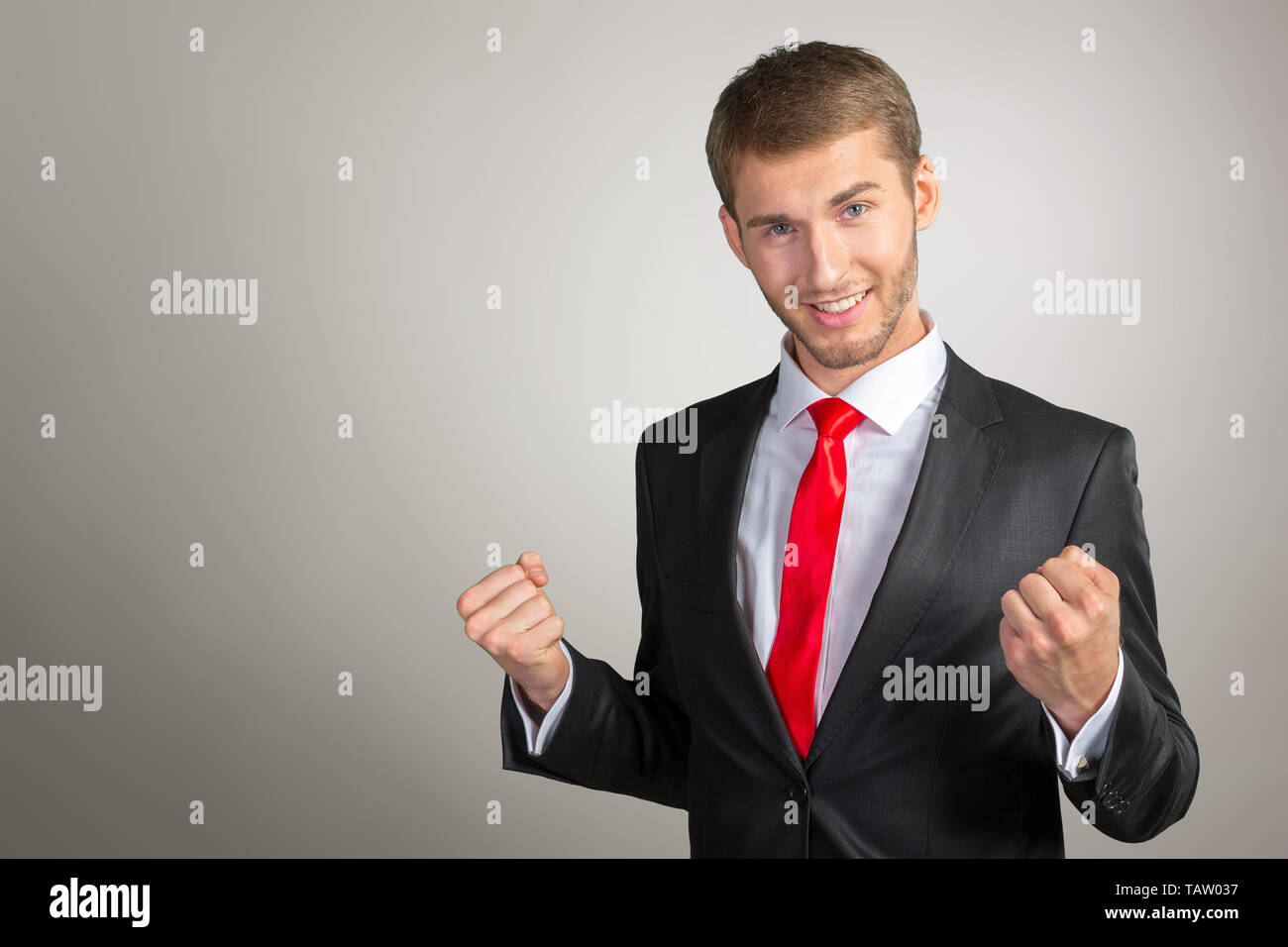 Successful young man celebrating with arms up Stock Photo - Alamy