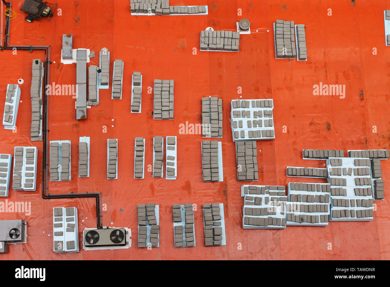 Boxes, pipes and other clutter on the orange roof of a building in ...