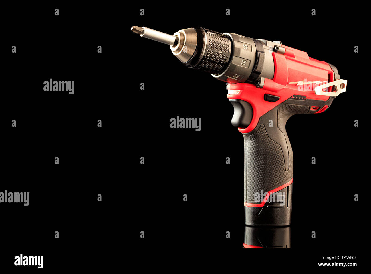 Cordless drill screwdriver red with rubberized grip isolated on a black ...