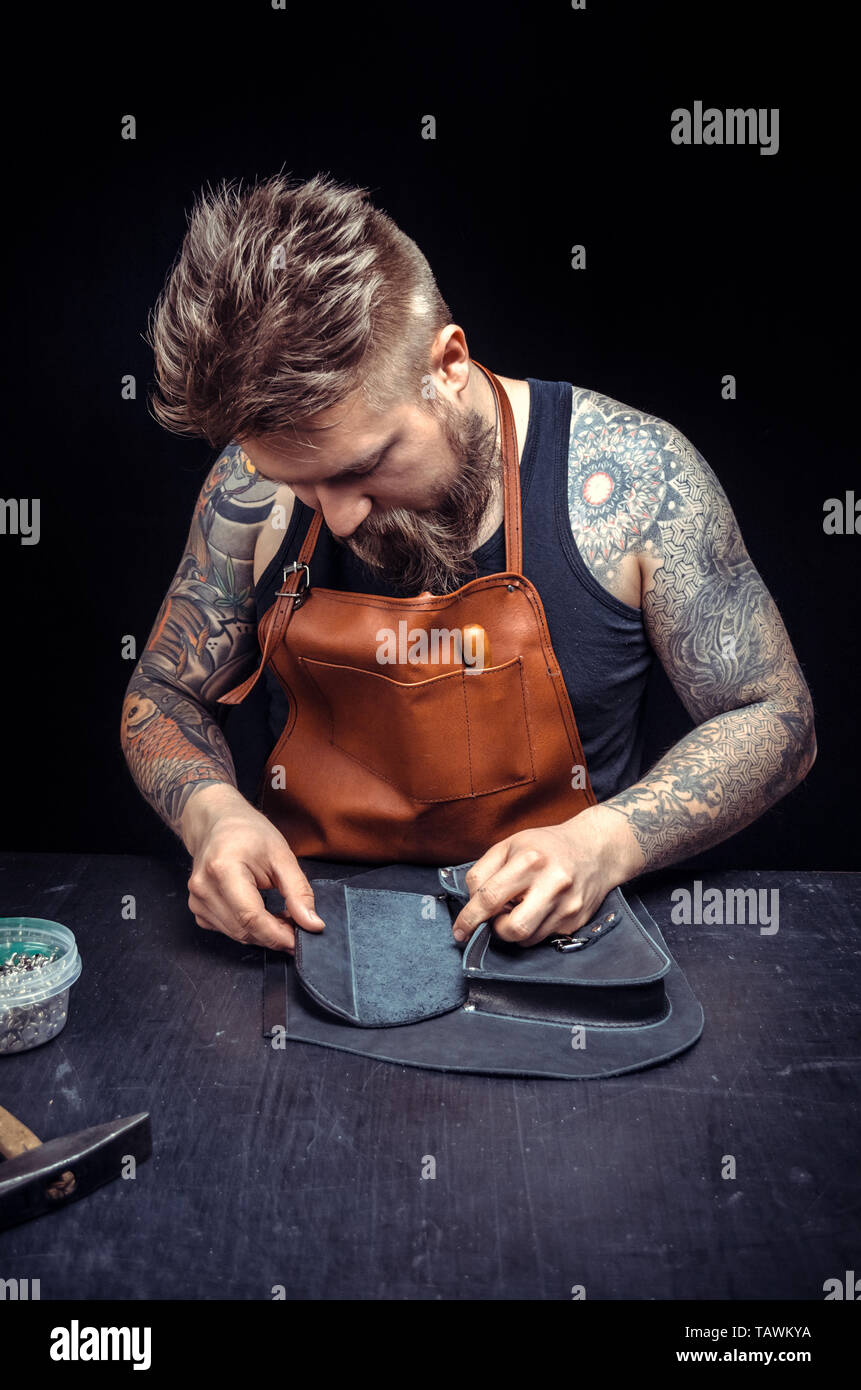 Leather Worker creating new leatherwork at his leather studio Stock ...
