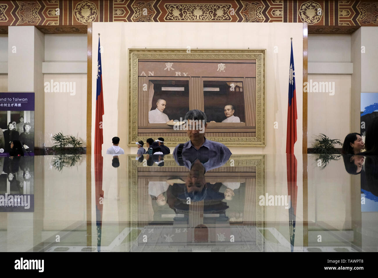 Visitors walk past a painting featuring Chiang Kai-shek displayed in an ...