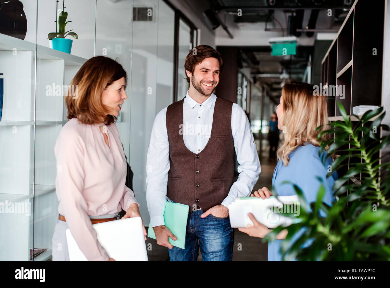 Group of business people standing in an office building, talking Stock ...