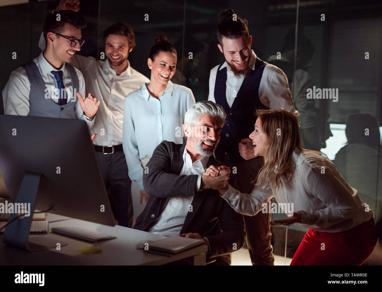 A group of business people with computer in an office, expressing ...