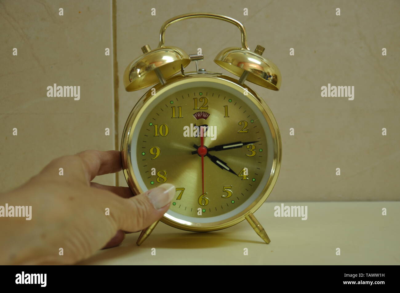 Hand is touching the alarm clock Stock Photo - Alamy