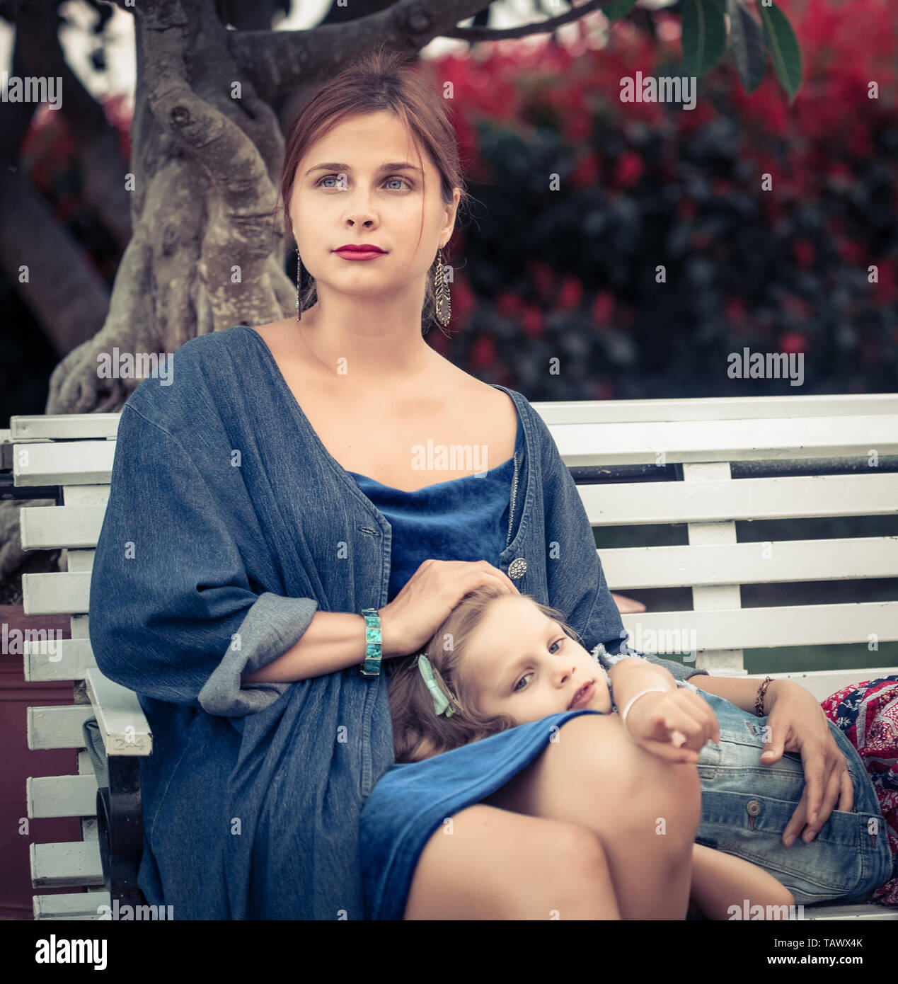 Mother and daughter sitting on a bench in a park Stock Photo - Alamy