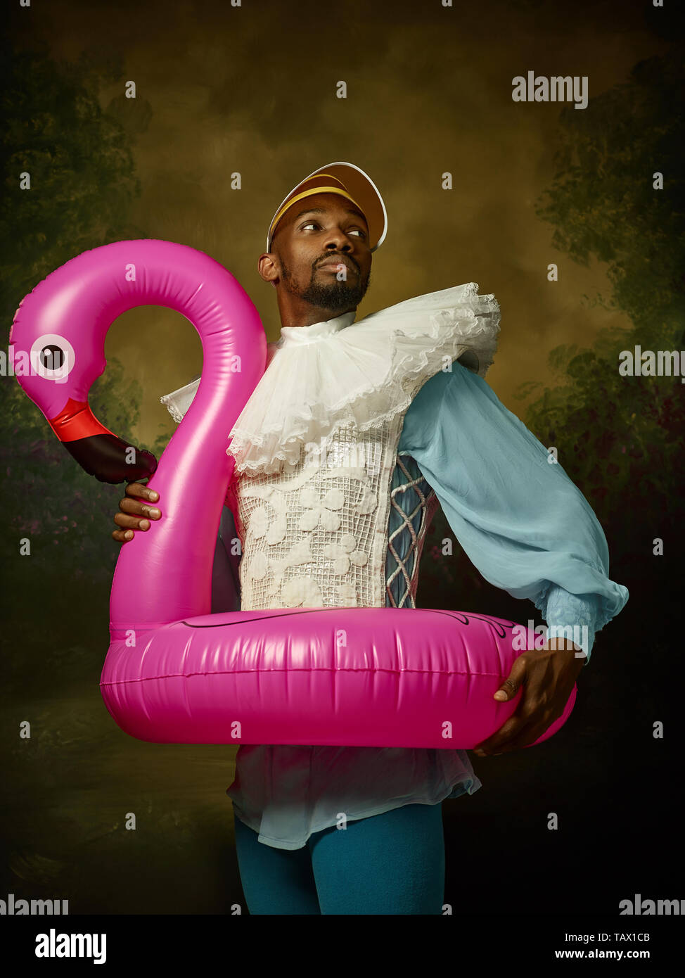 Young man as a medieval grandee or nobleman in a swimring as a pink ...