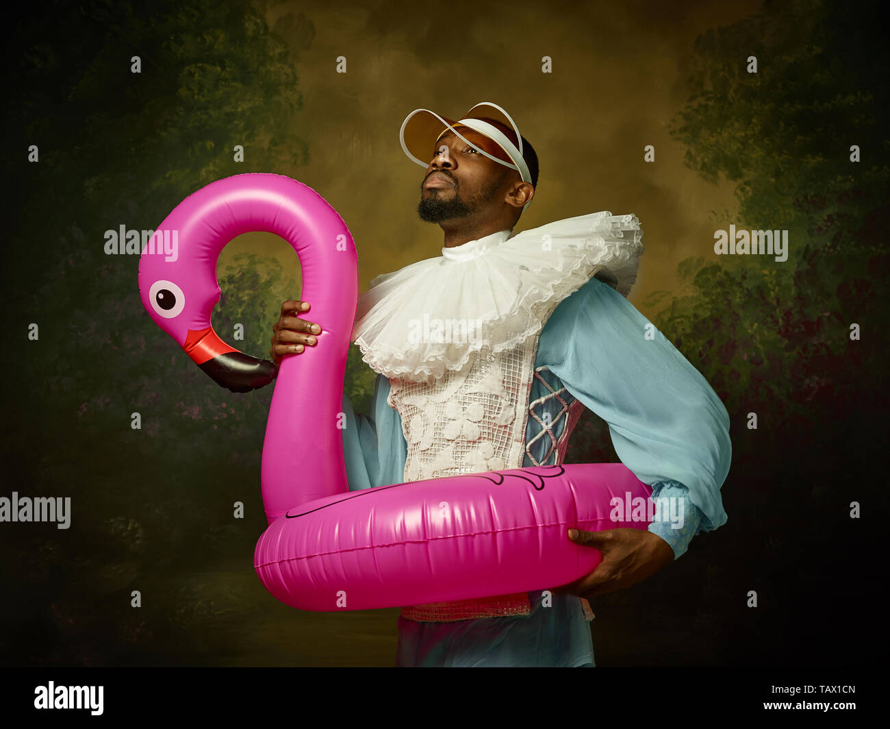 Young man as a medieval grandee or nobleman in a swimring as a pink ...