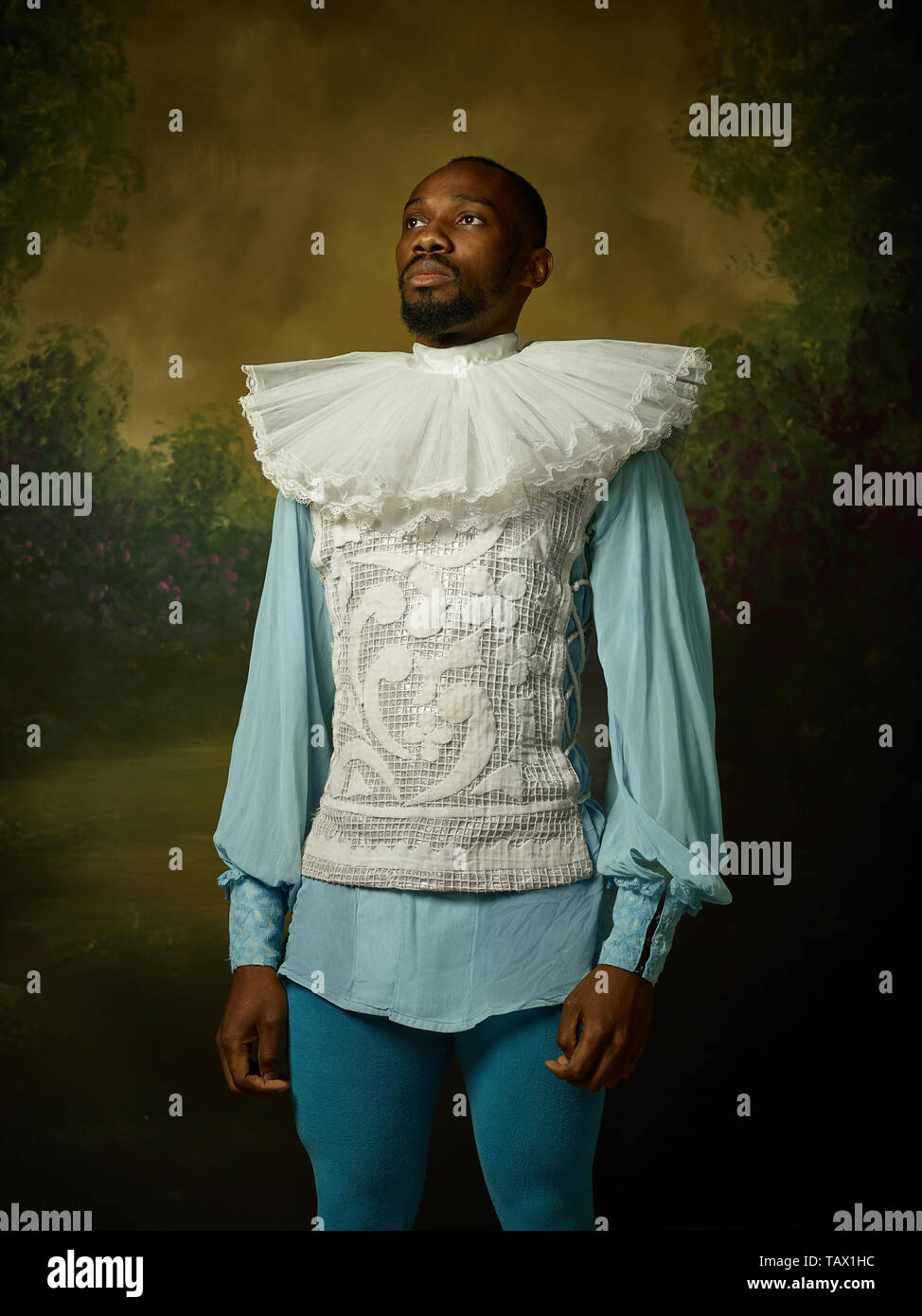 Young man as a medieval grandee or nobleman on dark studio background ...