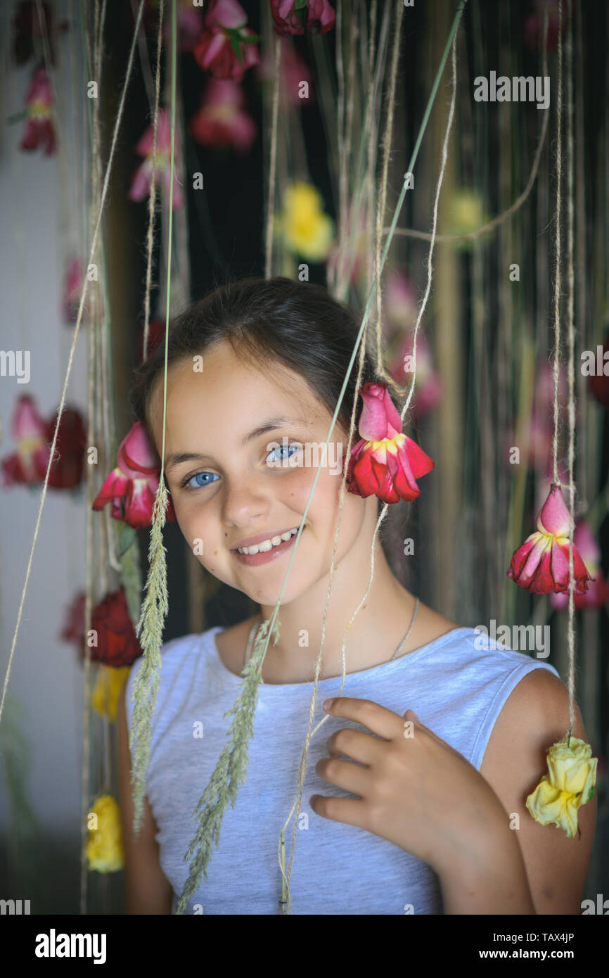 Child smile with roses in flower shop. Child, childhood, youth concept ...