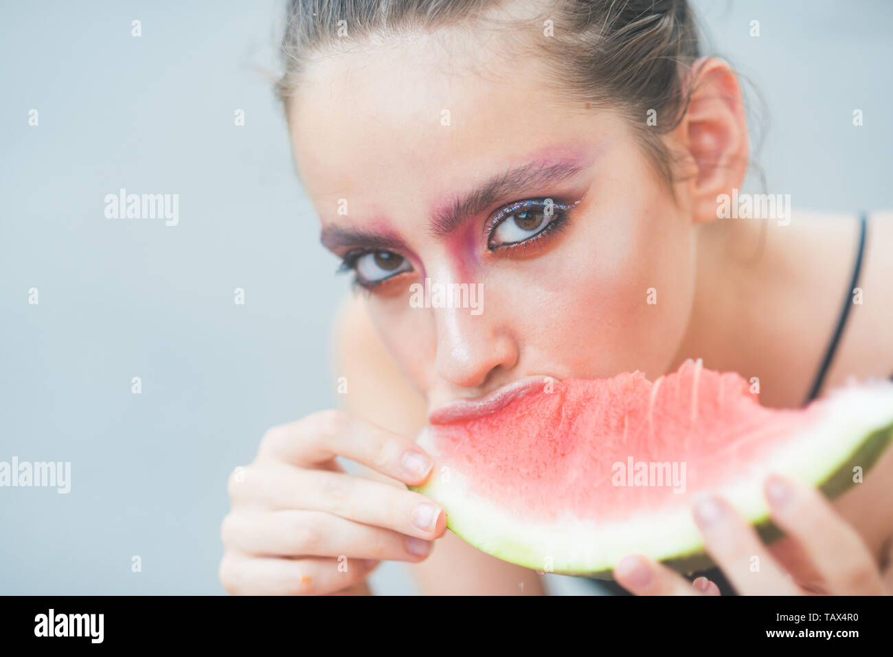 Food, diet, health. Young woman eat juicy watermelon. Girl with makeup ...