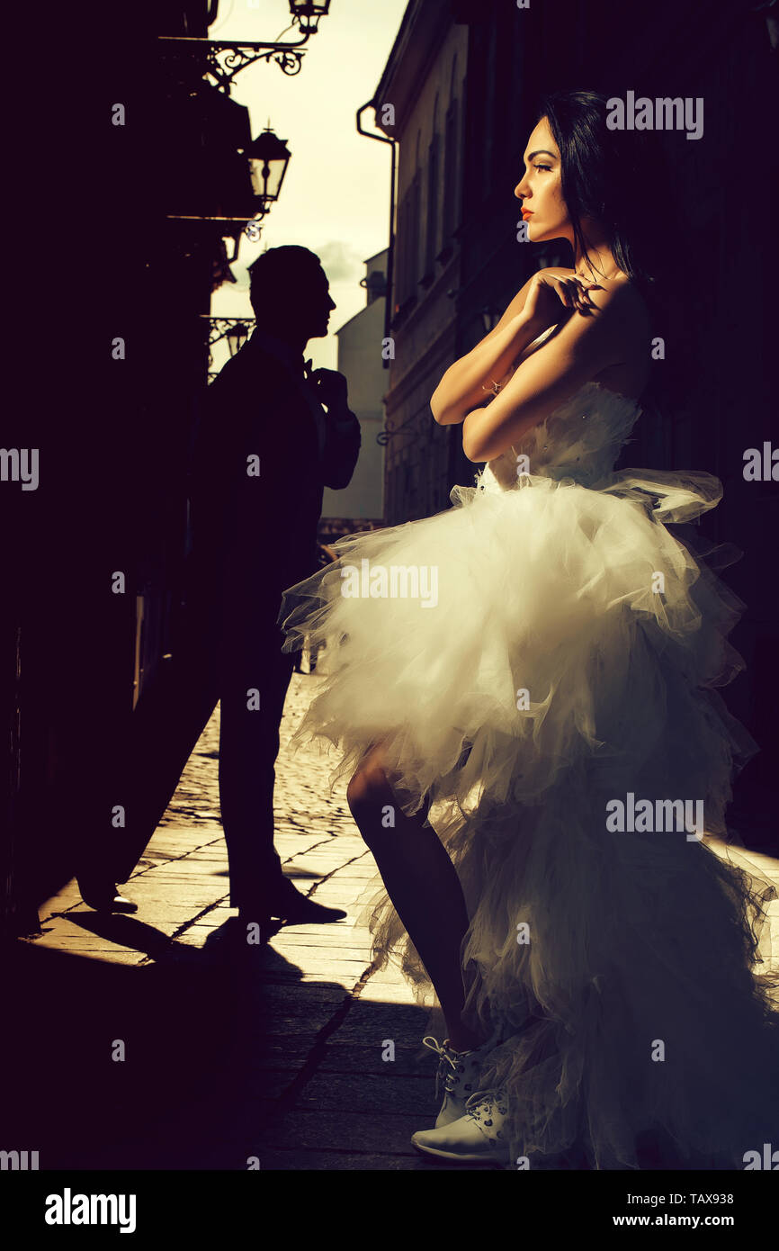 Beautiful bride in light and handsome groom in shadow married couple in ...