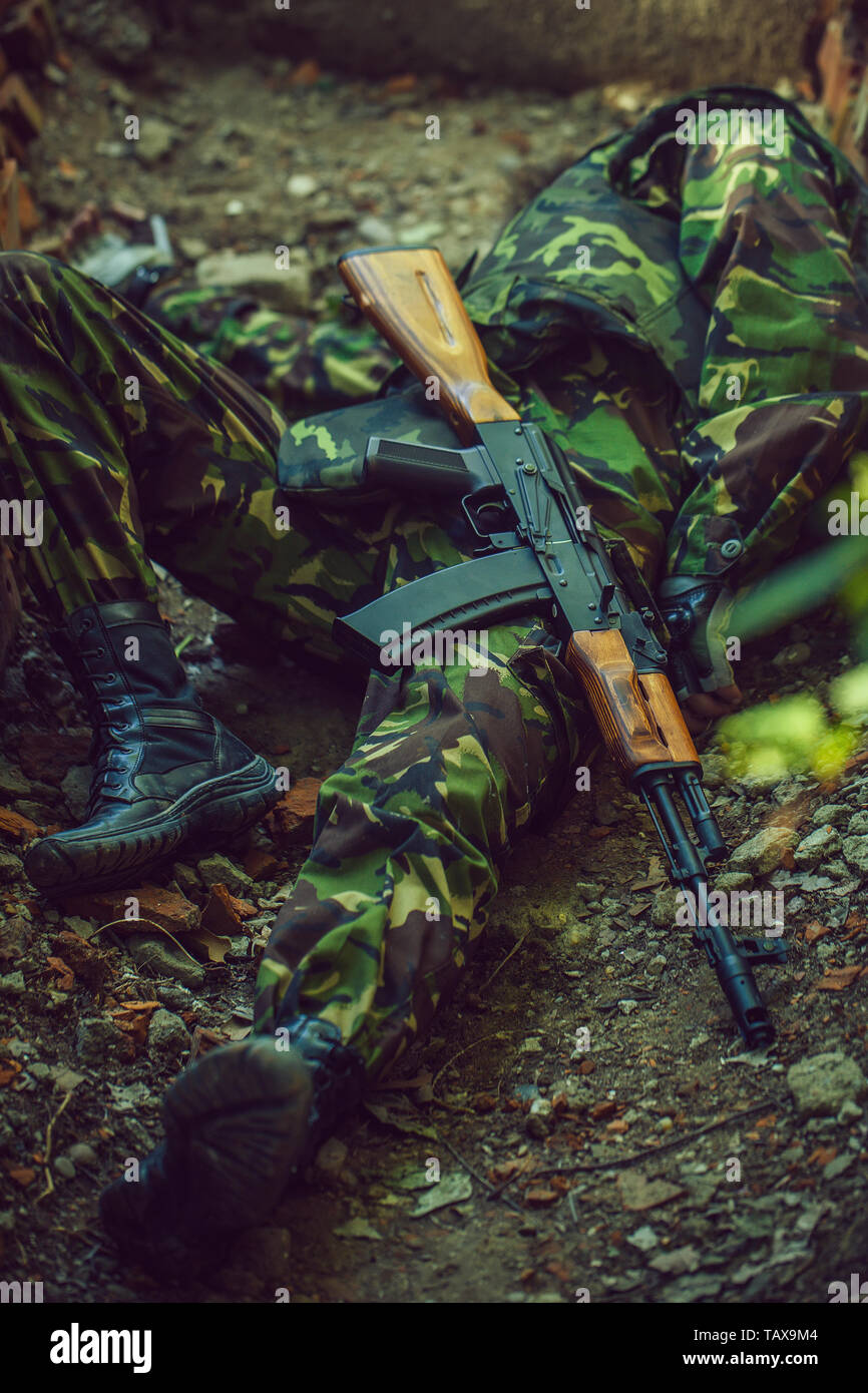 Dead body of killed soldier in war dressed in military ammunition ...