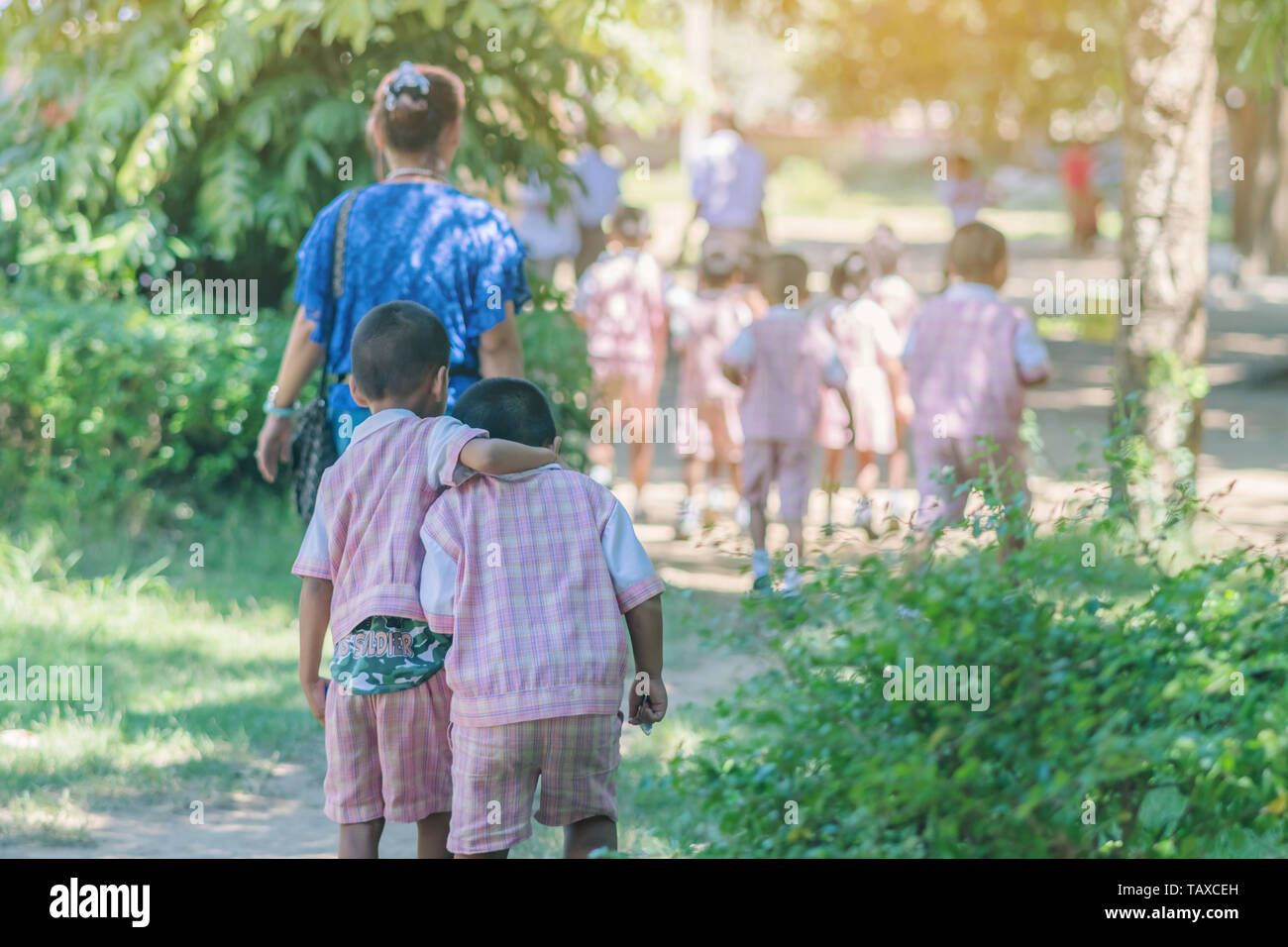 Kindergarten boy walk after female teacher and his friends back to ...