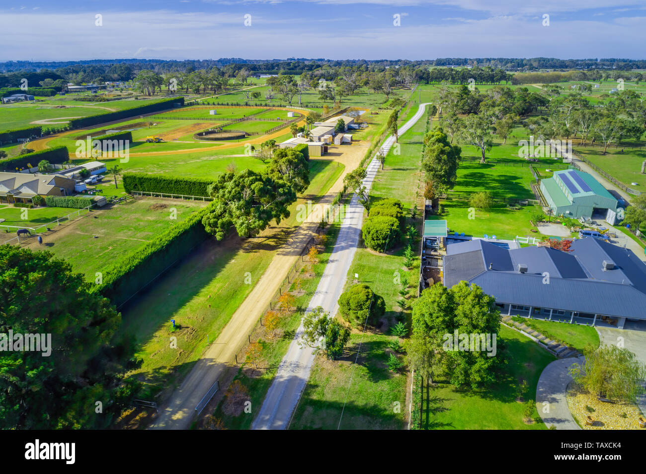Aerial view of rural road passing through agricultural land on bright ...
