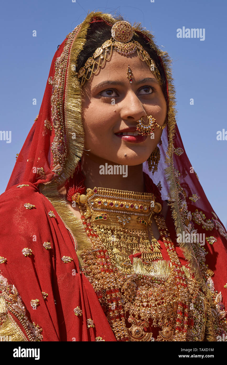 Indian lady dressed in ornate red sari and adorned with traditional ...