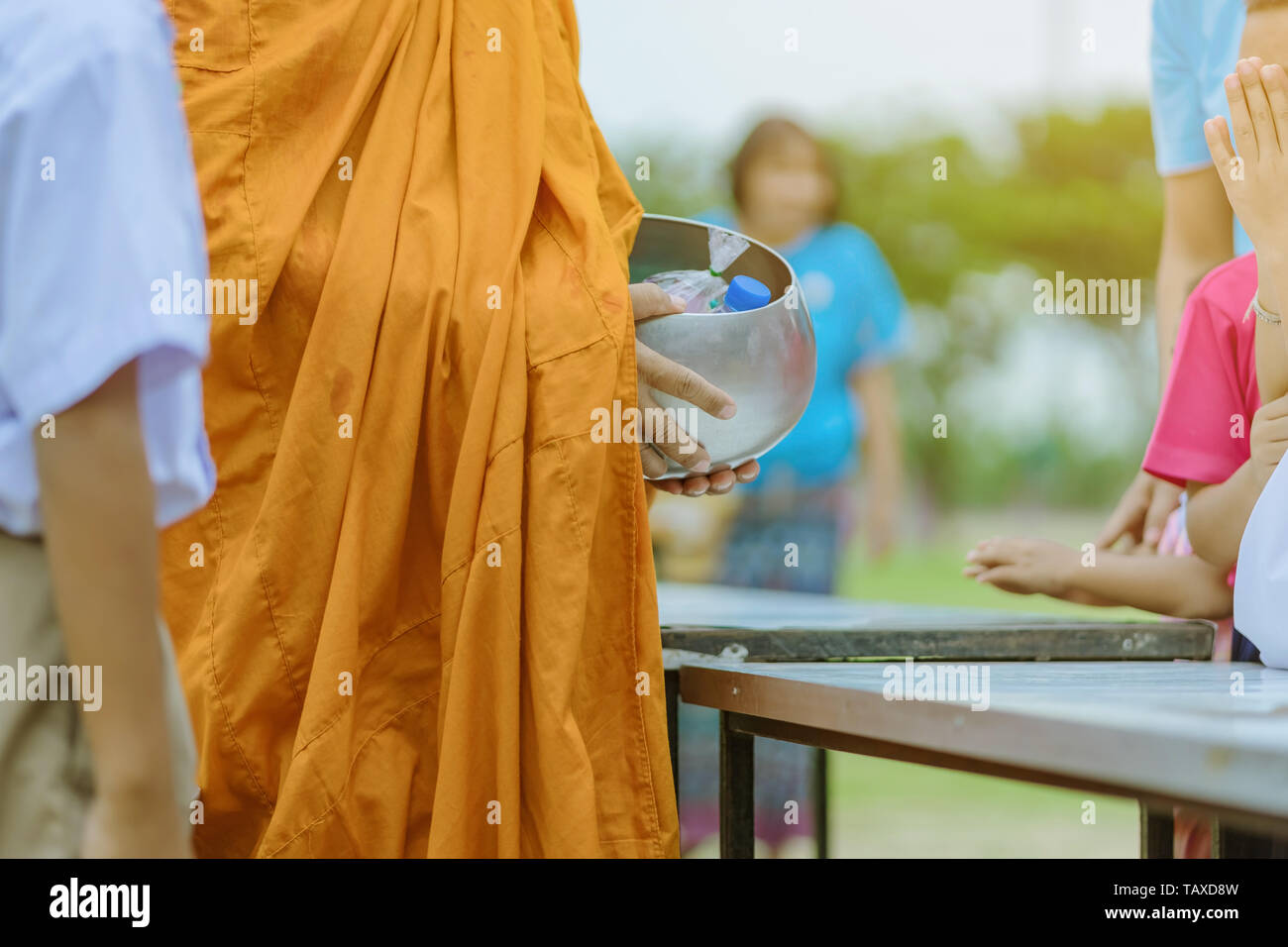Teachers and students together make merit to give food offerings to a ...