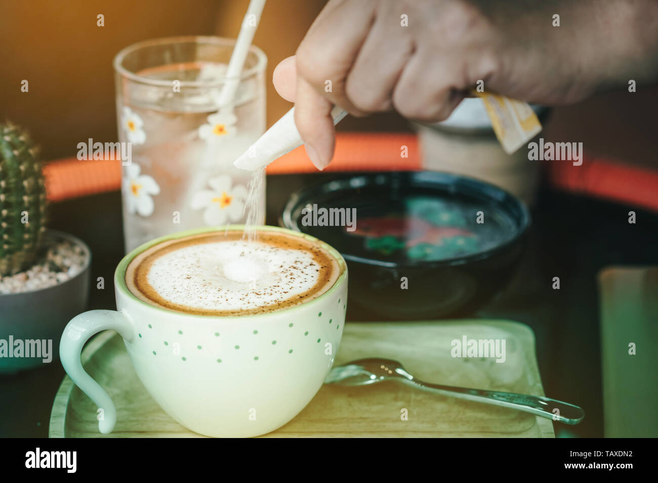 Woman pouring sugar into a white cup of coffee, Selective focus on ...