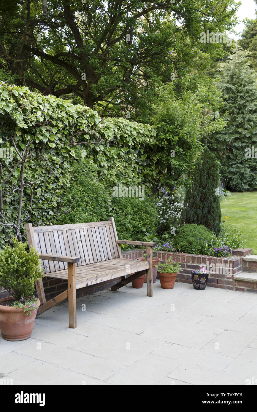 A typical English back garden in the UK, with flag stone patio and ...
