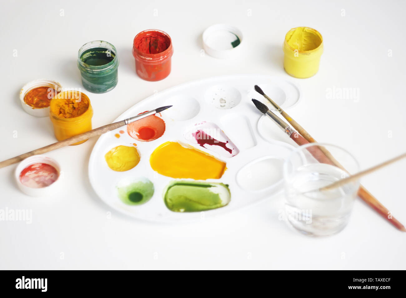 On a white background there is a still life with art supplies: gouache ...