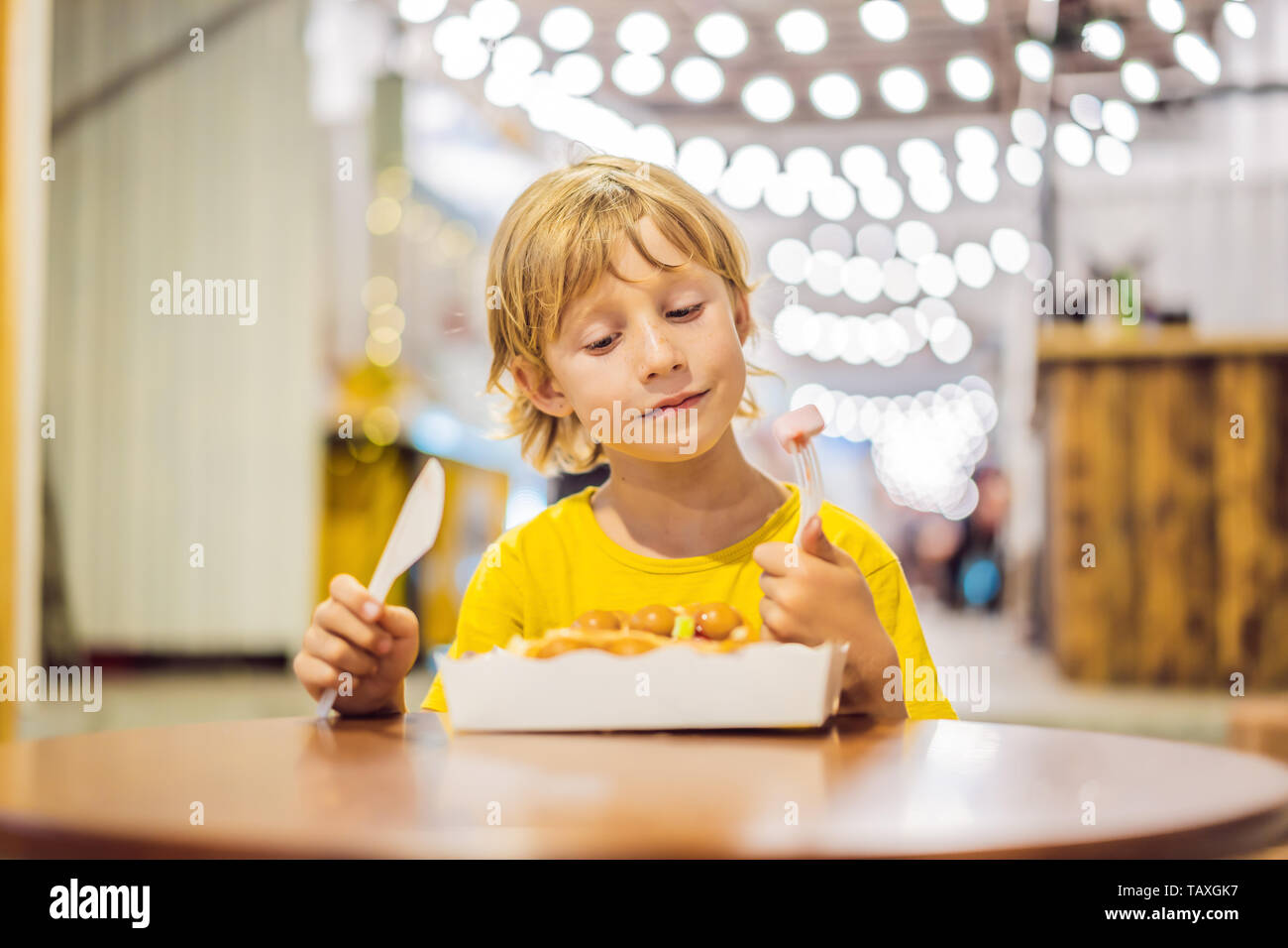 A little boy eats dessert waffles with jam in a cafe Stock Photo - Alamy
