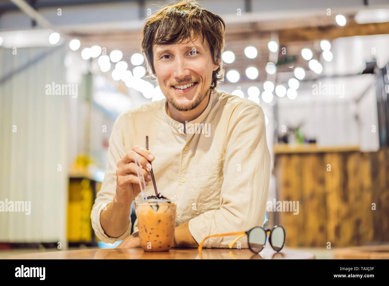Man drinking cold bubble tea in cafe Stock Photo - Alamy