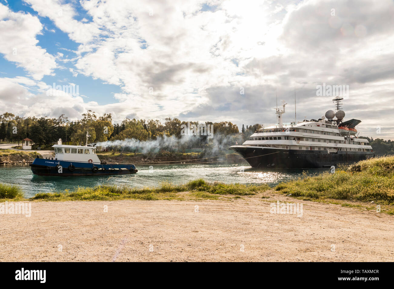 Corinth, Greece. Large ship with tugboat crossing the Corinth Canal, a ...