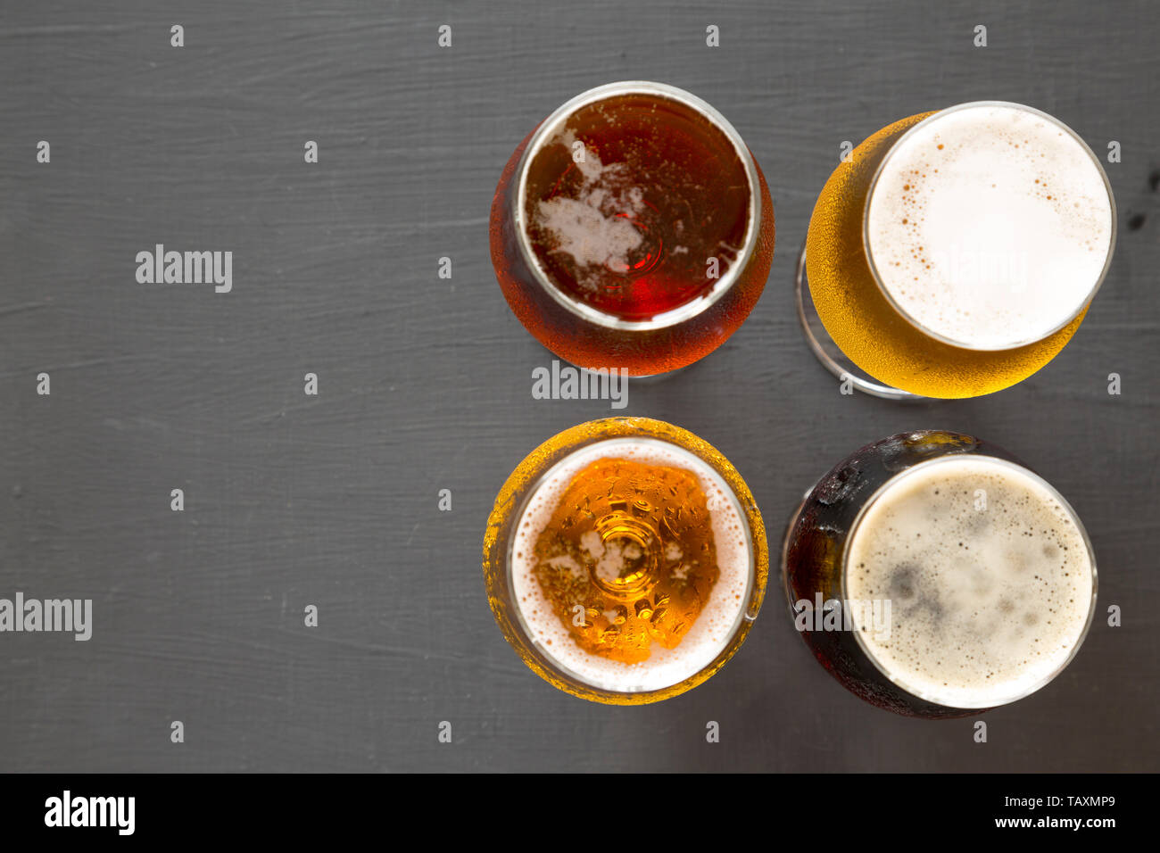 Assorted beers on a black surface, top view. Overhead, from above. Copy ...