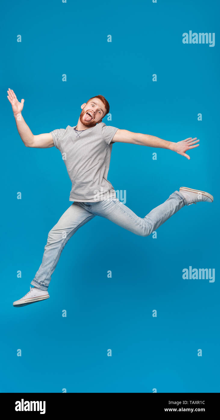Funny millennial guy jumping in air and fooling Stock Photo - Alamy