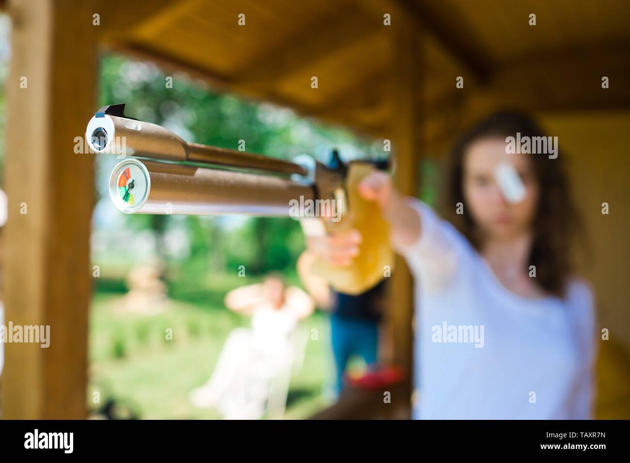 Aiming sport shooter, detail on compensator and air gauge on front of ...