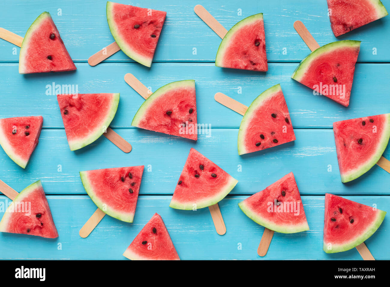 Sliced juicy fruit on wooden sticks, blue background Stock Photo - Alamy