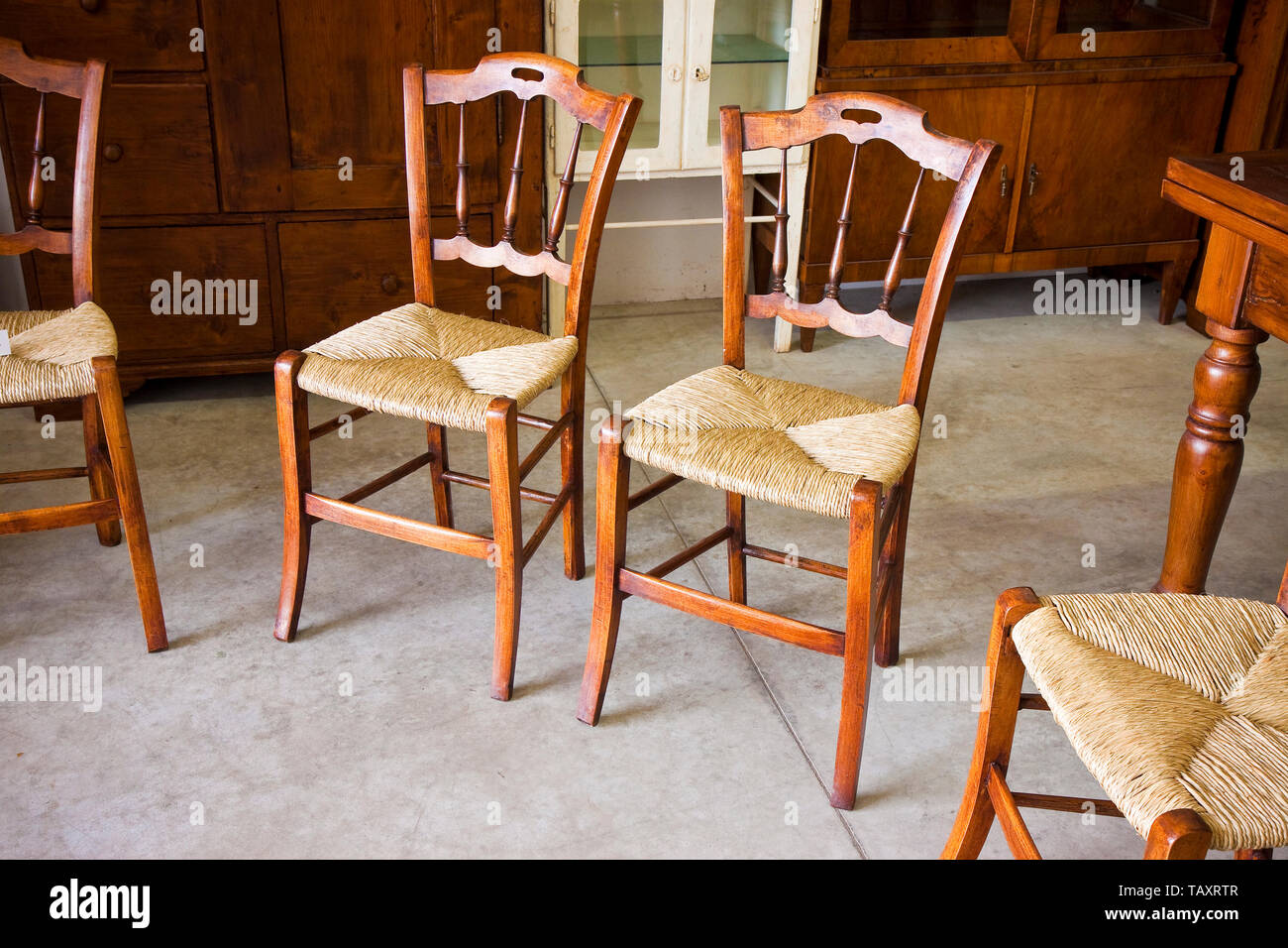 Typical italian wooden straw chairs with turned parts in a junk dealer ...