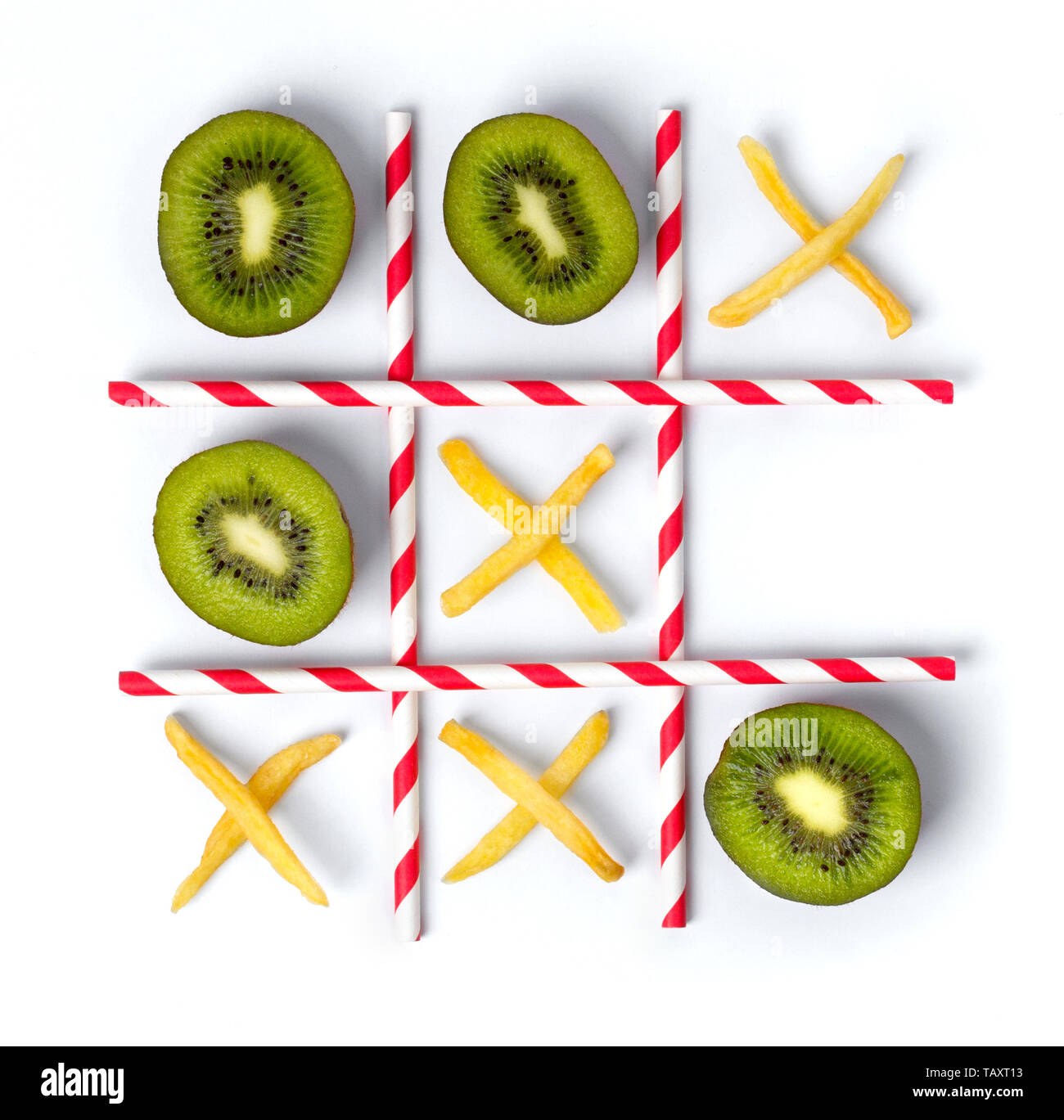 Flat lay Tic tac toe made of kiwi, fries and straws. Healthy vs junk ...