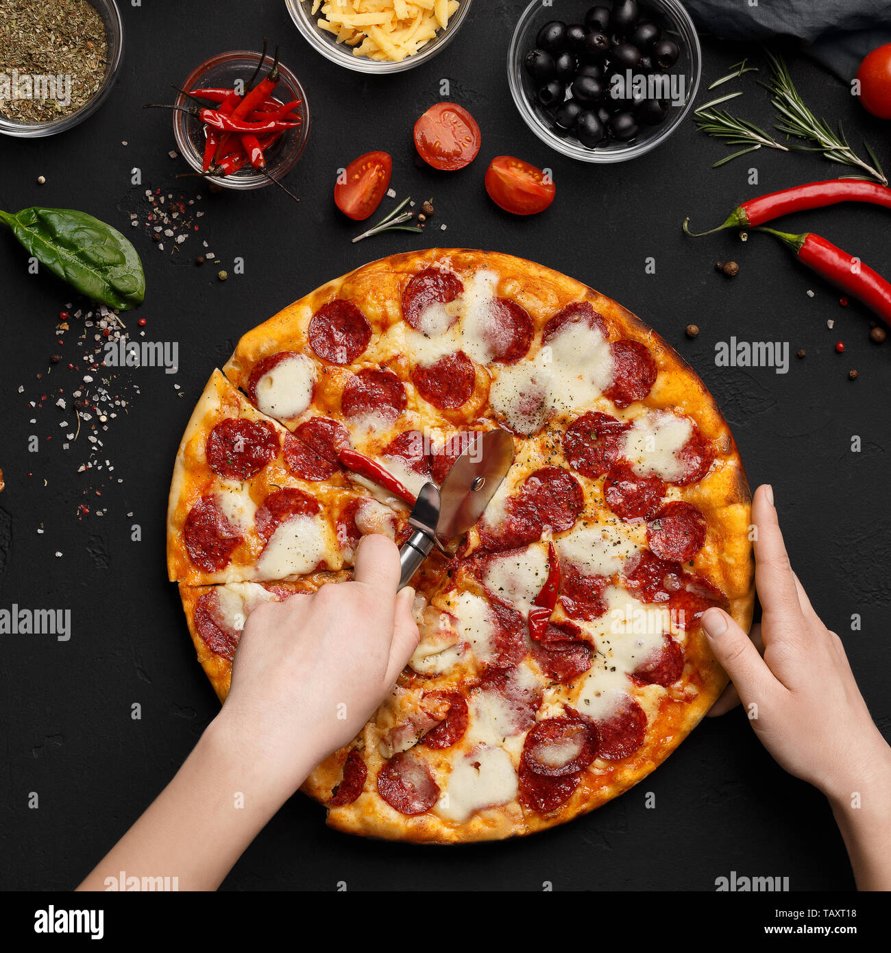 Woman Cutting Hot Pepperoni Pizza Into Slices Stock Photo - Alamy
